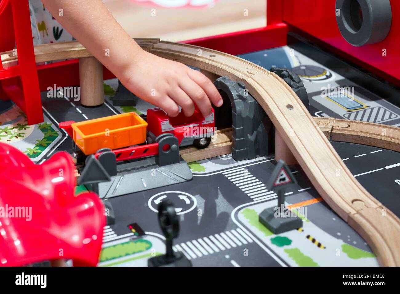 Close-up of a child's arm and hand playing with a toy train set Stock ...