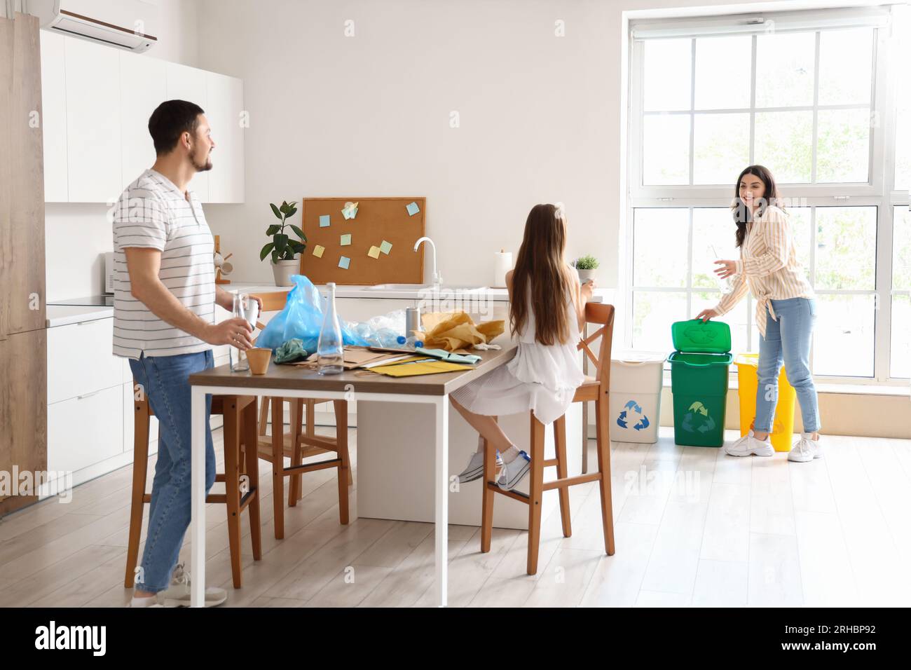 Family sorting garbage with recycle bins in kitchen Stock Photo - Alamy