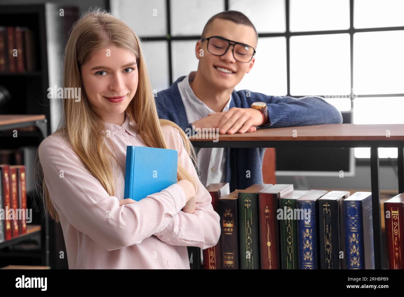 Female student with her classmate in library Stock Photo - Alamy