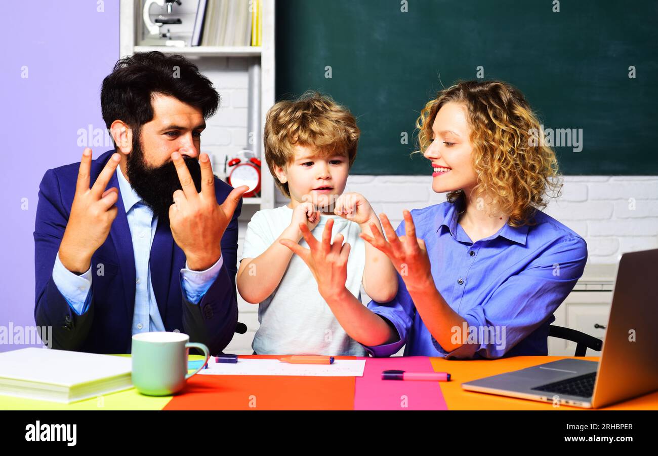 Cute pupil learning math and counting on fingers with parents. Little ...