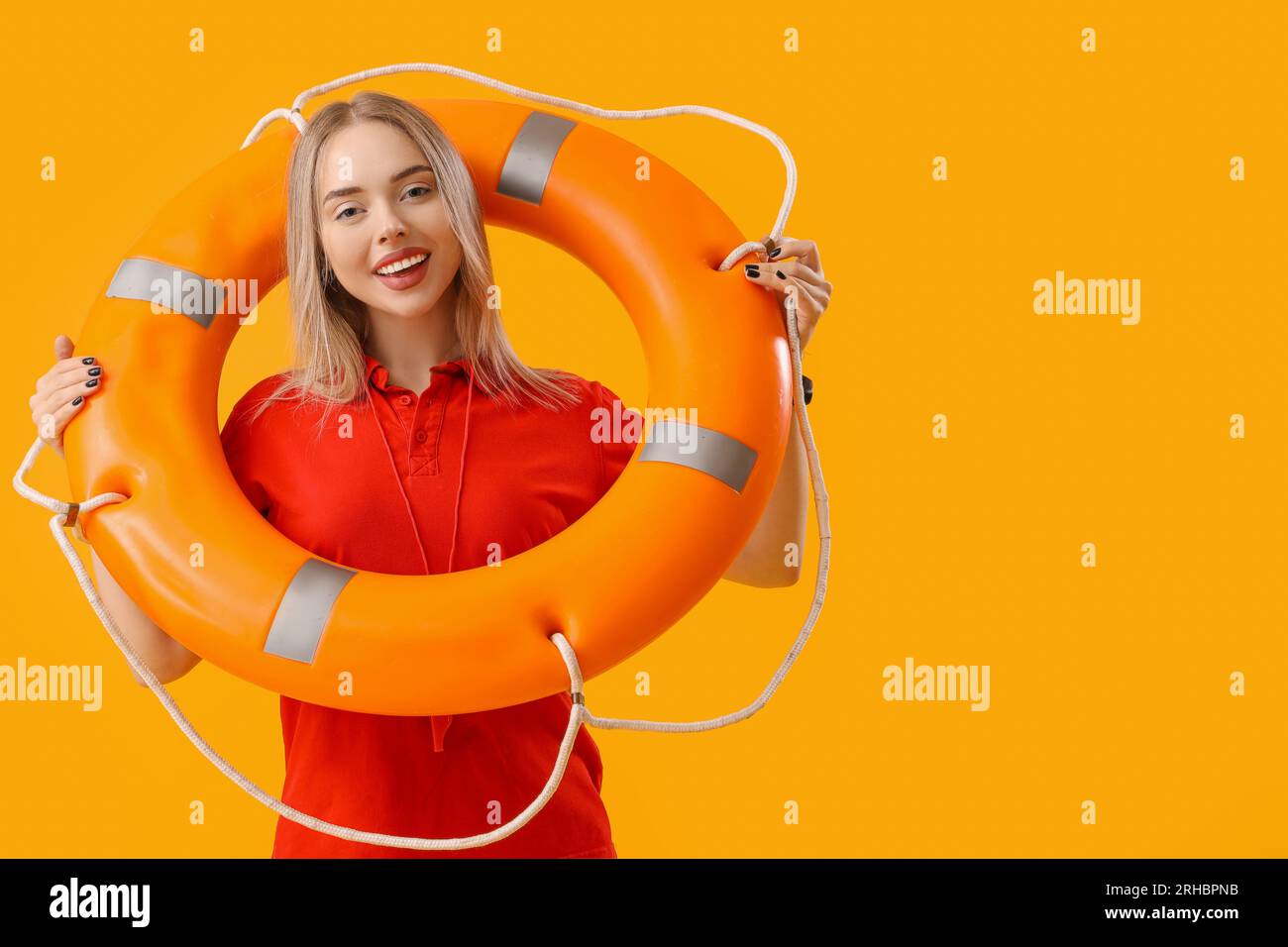 Female lifeguard with ring buoy on yellow background Stock Photo - Alamy