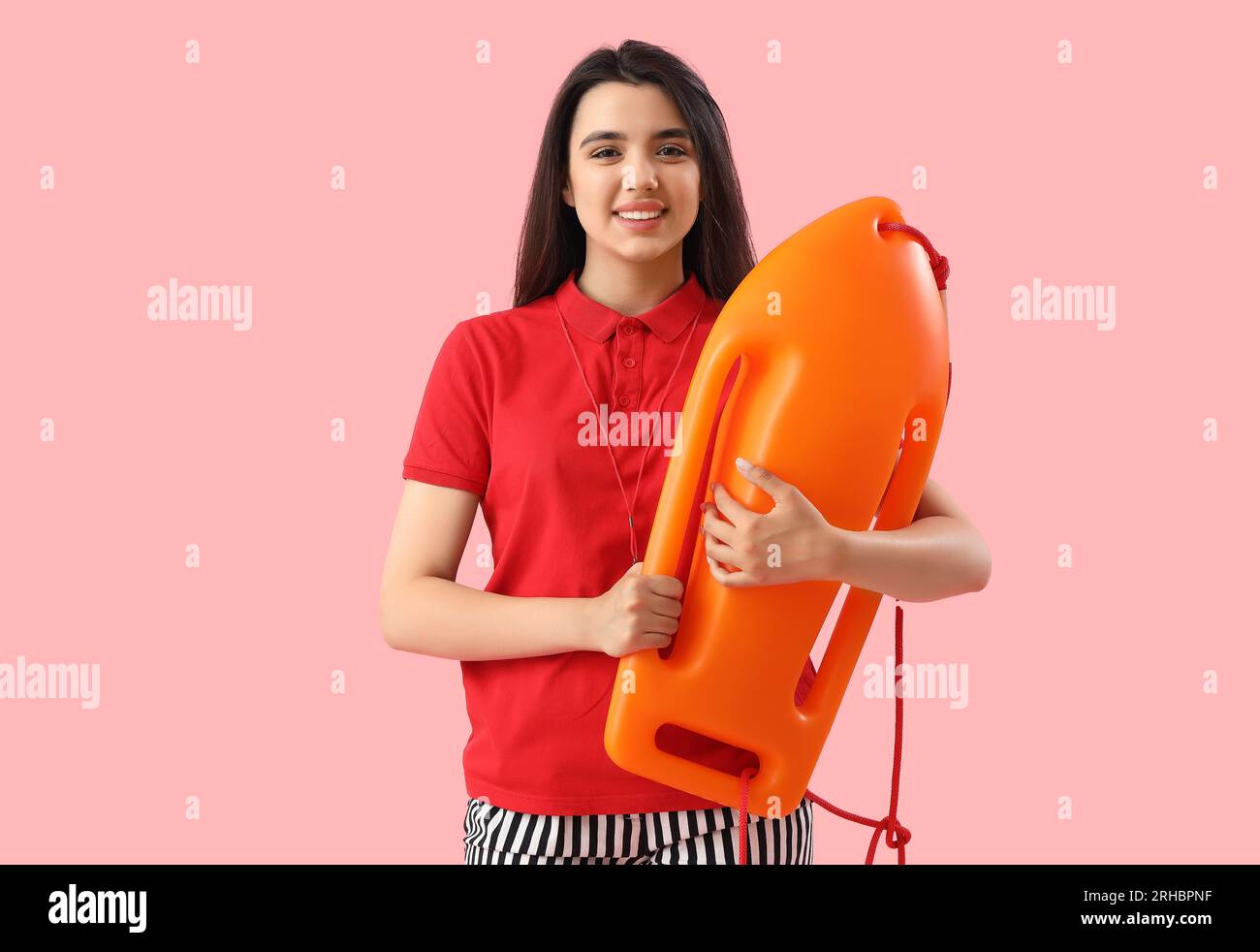Female lifeguard with board on pink background Stock Photo - Alamy