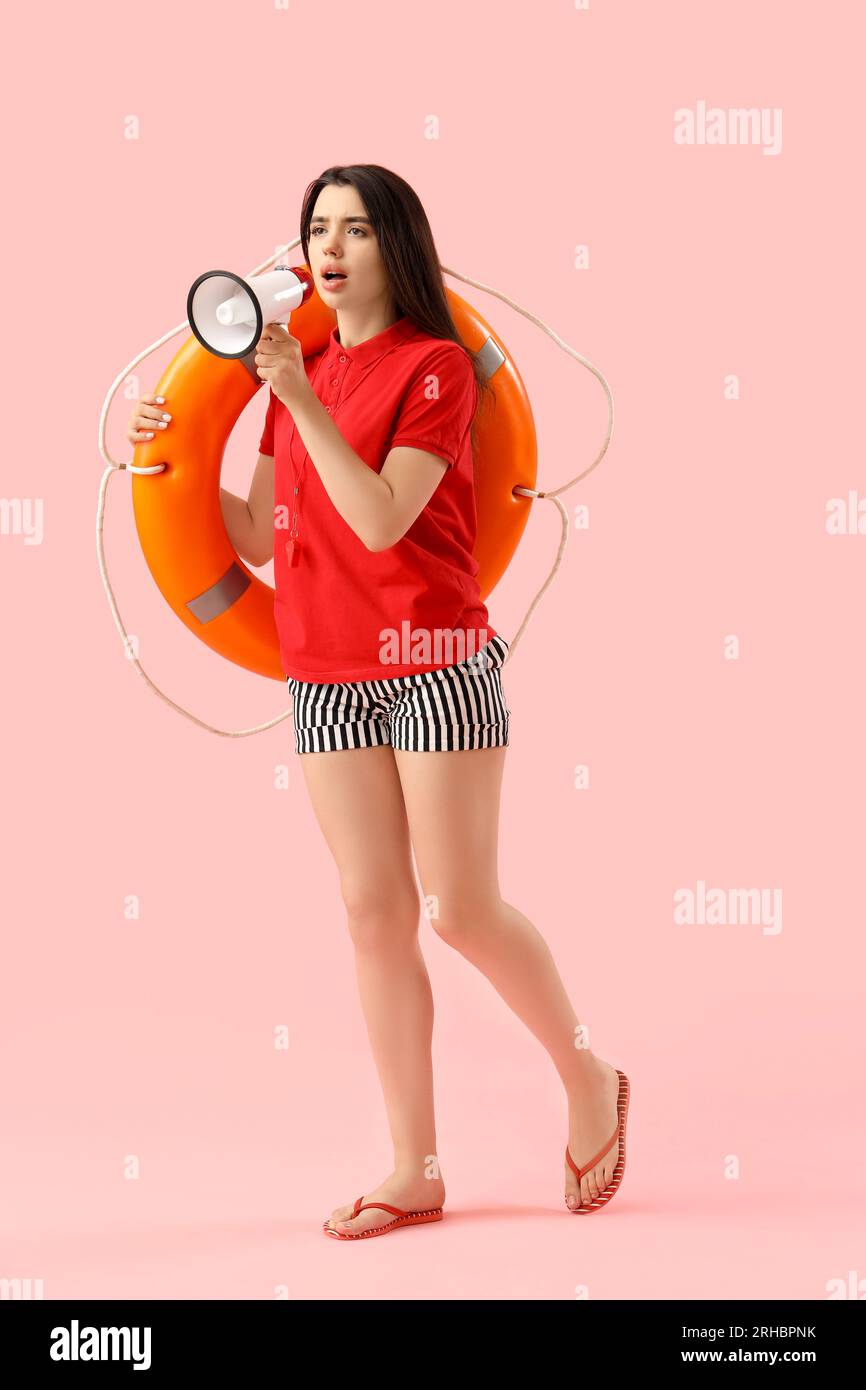Female lifeguard with megaphone and ring buoy on pink background Stock ...
