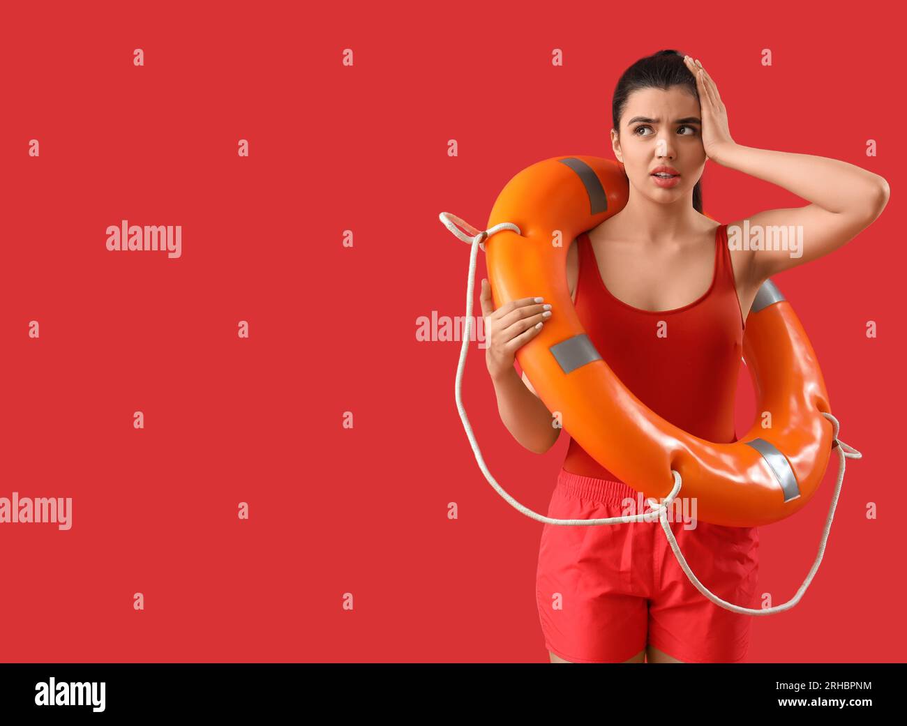 Shocked female lifeguard with ring buoy on red background Stock Photo ...