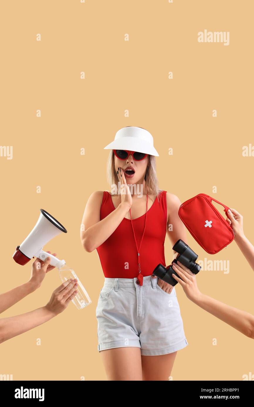 Shocked female lifeguard and hands with items on beige background Stock ...