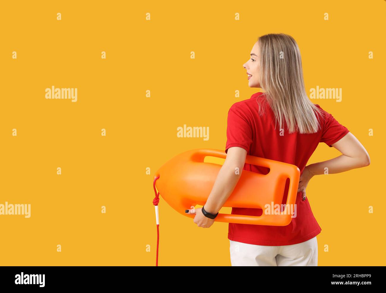 Female lifeguard with rescue buoy on yellow background, back view Stock ...