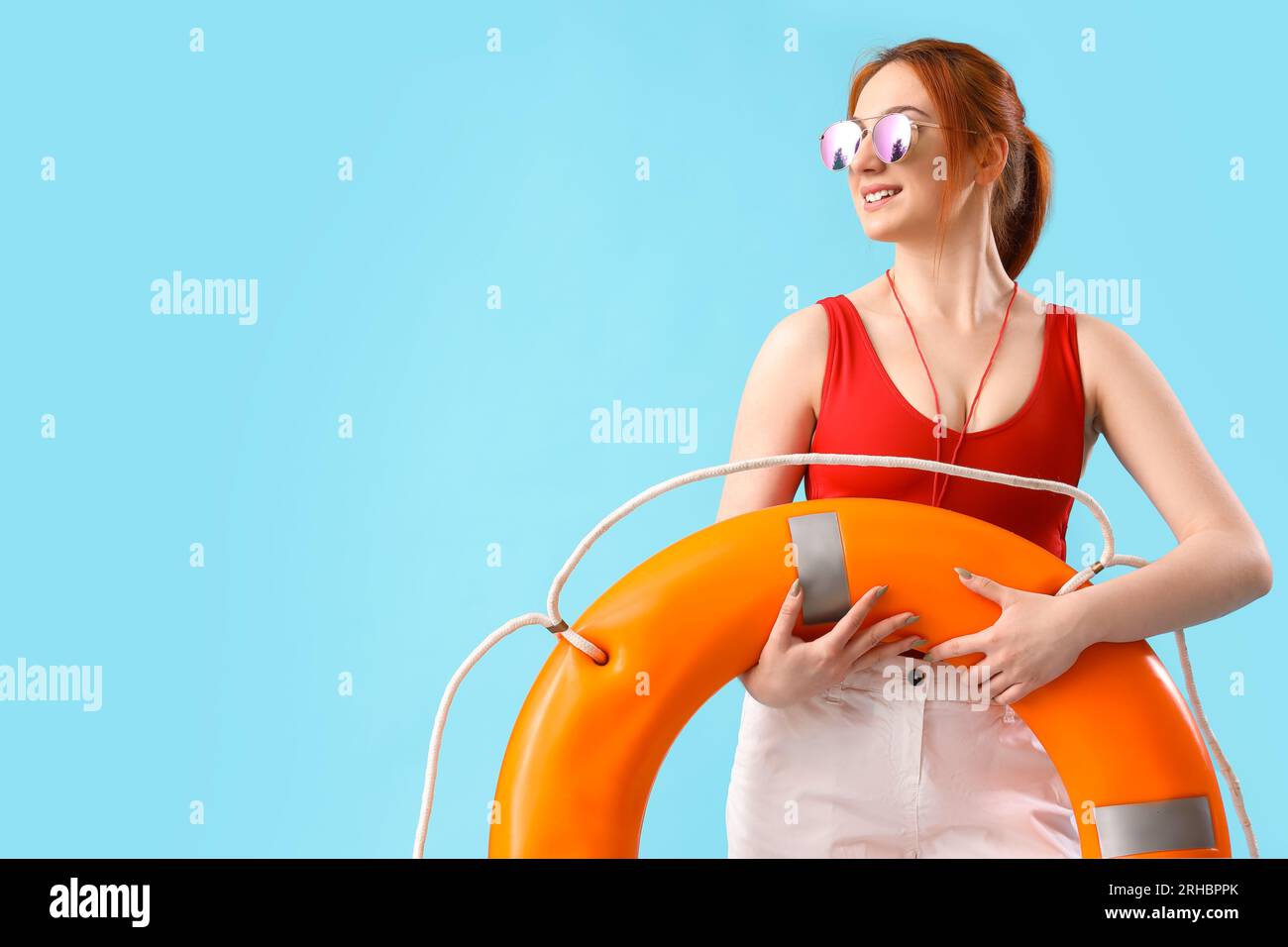 Female lifeguard with ring buoy on blue background Stock Photo - Alamy