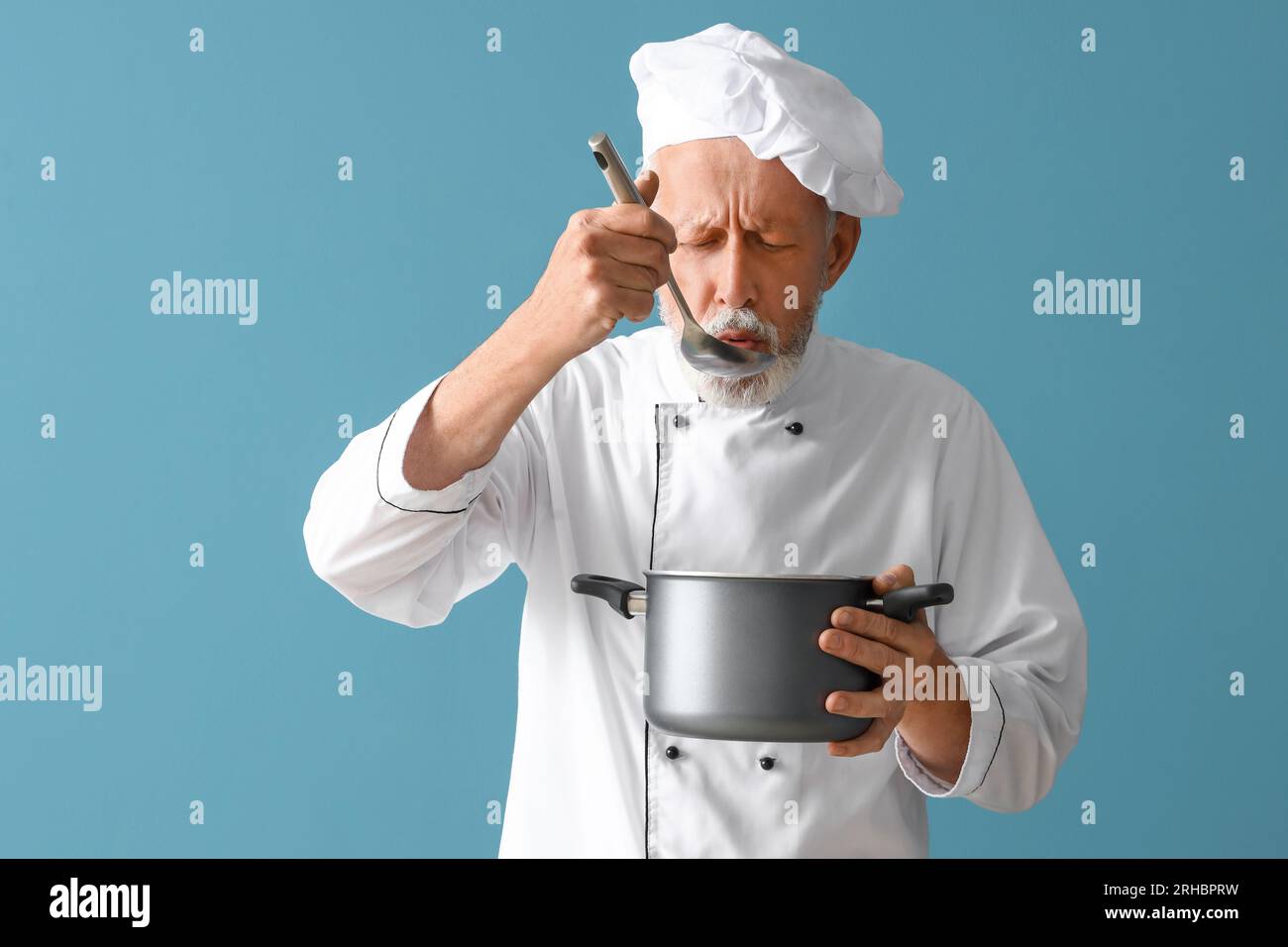 Mature chef with ladle and cooking pot on blue background Stock Photo ...