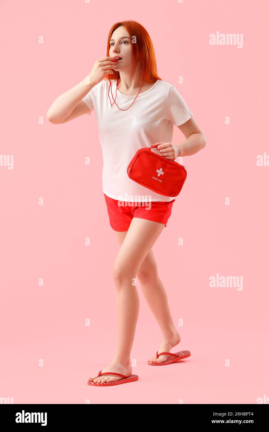 Female lifeguard with first aid kit whistling on pink background Stock ...
