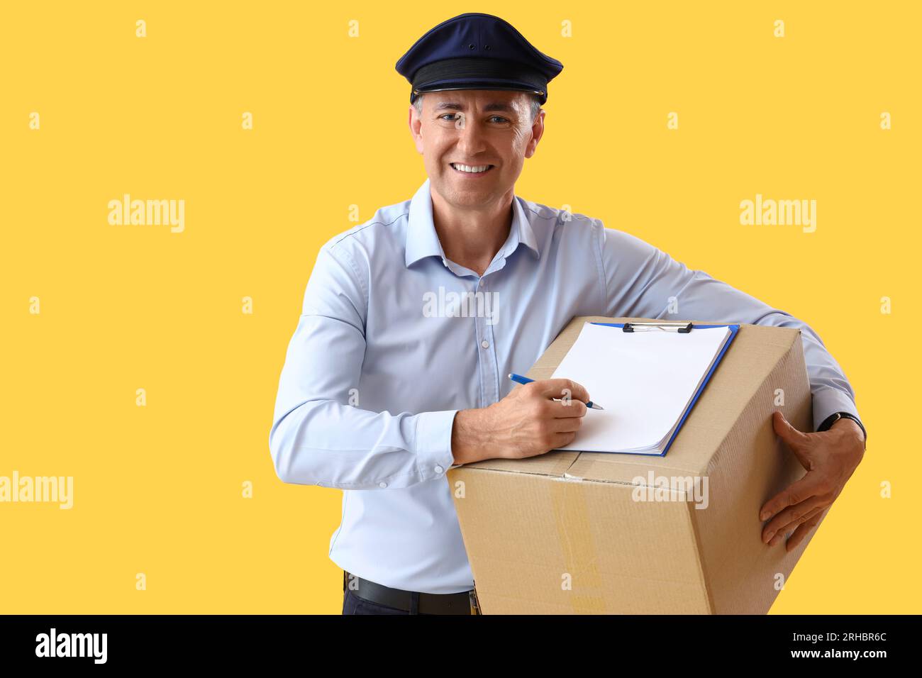 Mature postman with clipboard and parcel on yellow background Stock ...