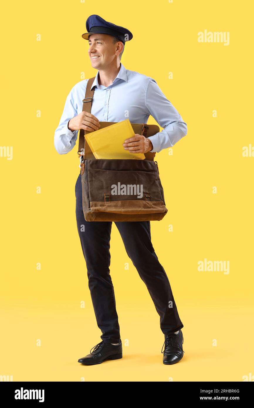 Mature postman with bag and envelope on yellow background Stock Photo ...
