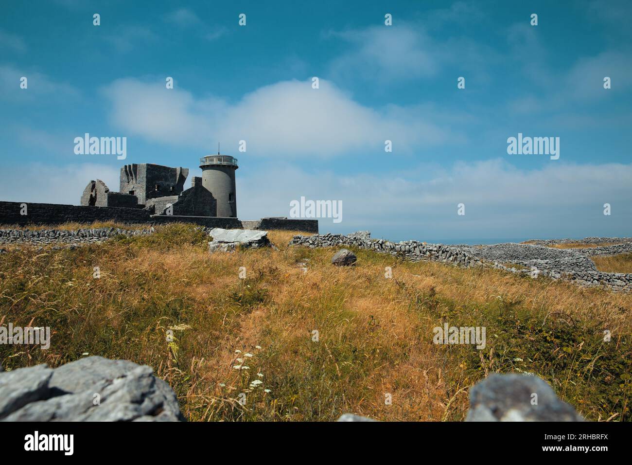 An old fort and tower overlook the north Atlantic ocean on Inishmore ...
