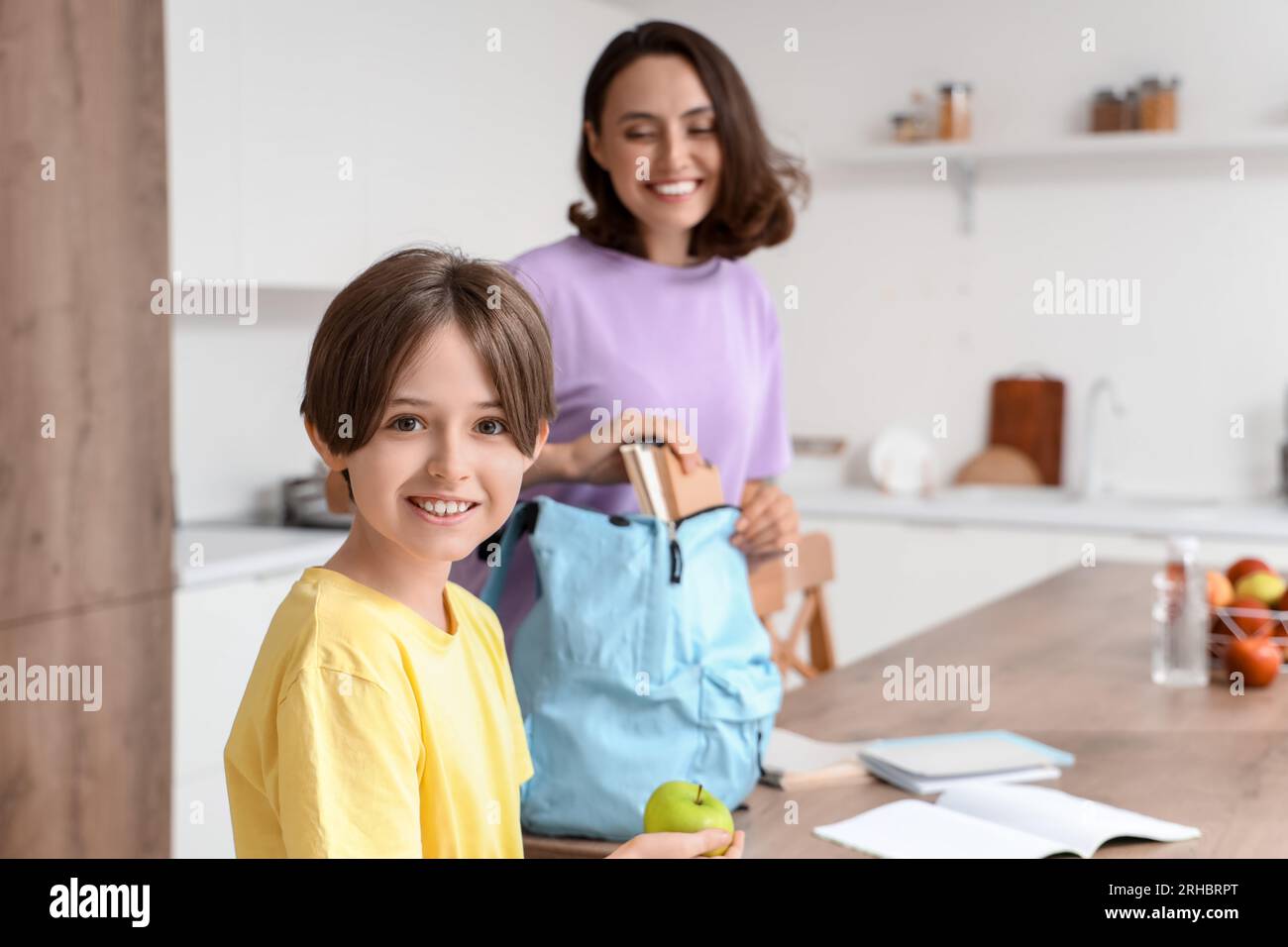 Mother packing her son's backpack to school at kitchen Stock Photo - Alamy