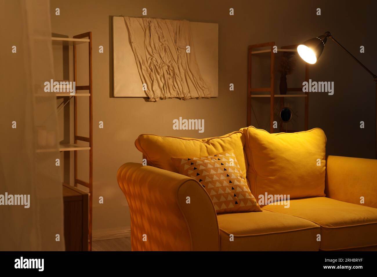 Interior of living room with sofa and glowing lamp at night Stock Photo ...