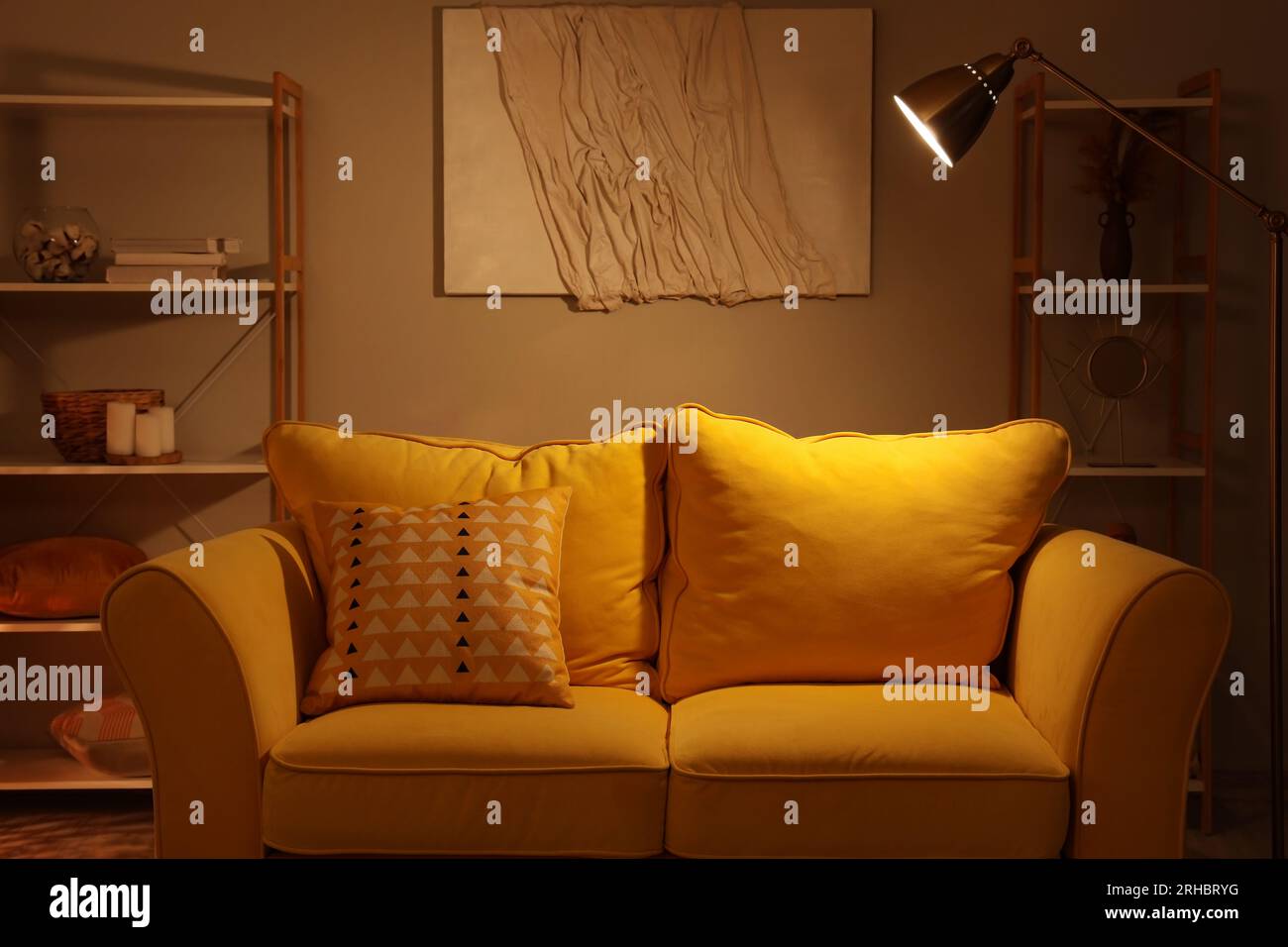 Interior of living room with sofa and glowing lamp at night Stock Photo ...