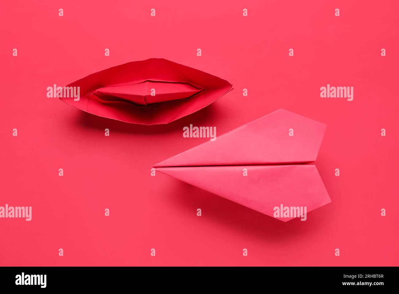 Origami boat and paper plane on red background Stock Photo - Alamy