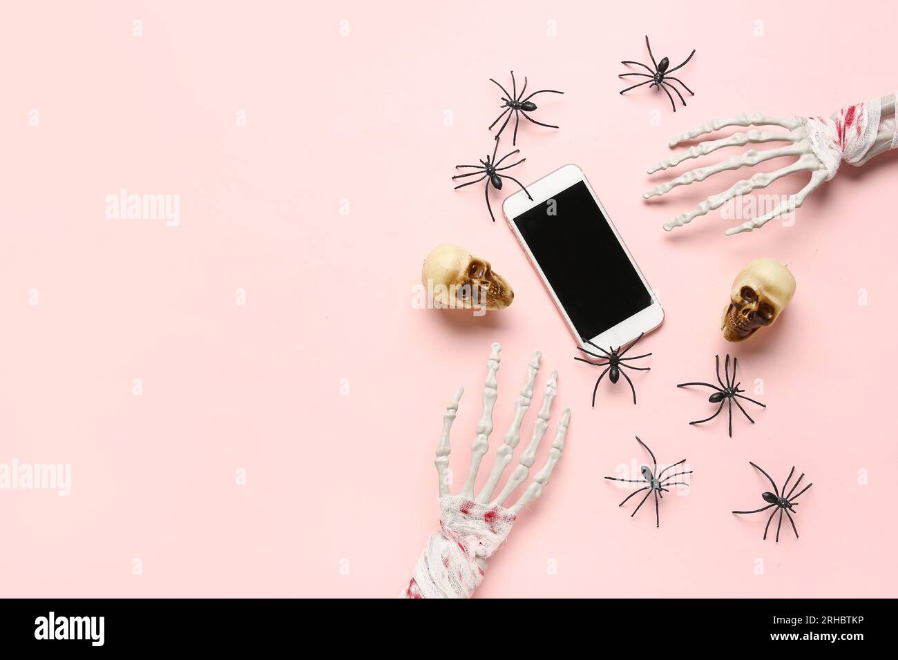 Skeleton hands with modern mobile phone, skulls and spiders for ...