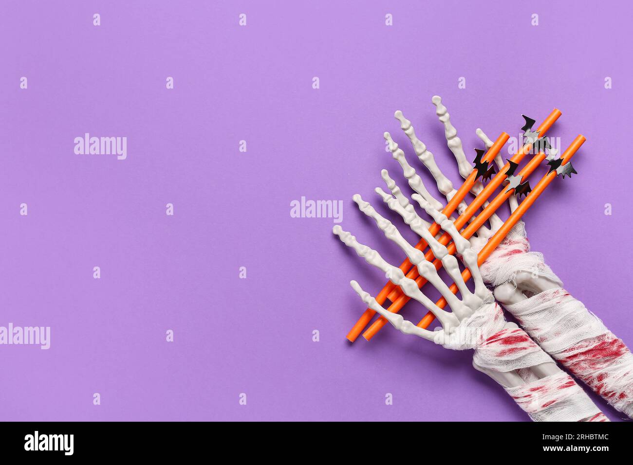 Skeleton hands with straws for Halloween celebration on purple ...