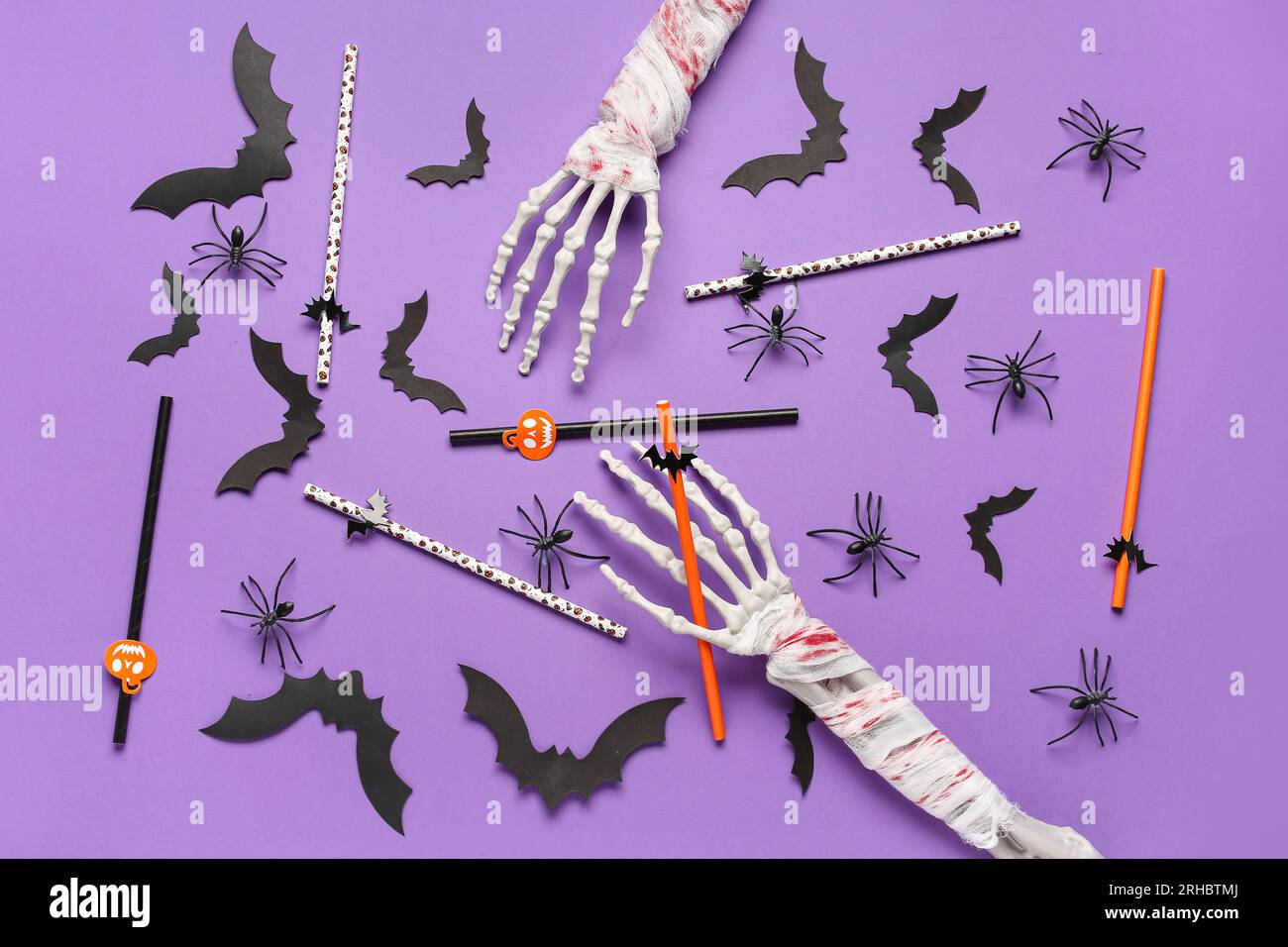 Composition with skeleton hands, straws and paper bats for Halloween ...