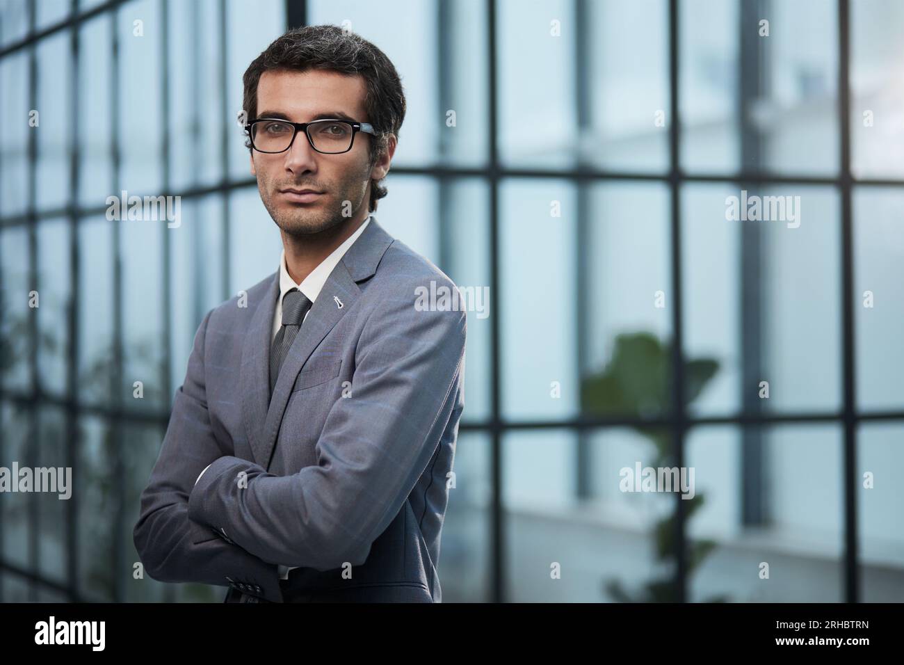 Dedicated to his business. Shot businessman standing with his arms ...