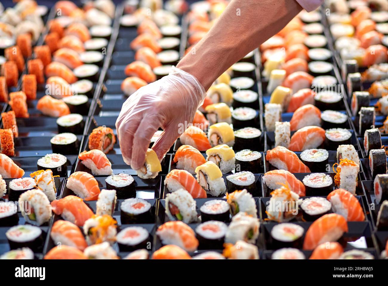 Crop anonymous male seller taking roll from stall while working in ...