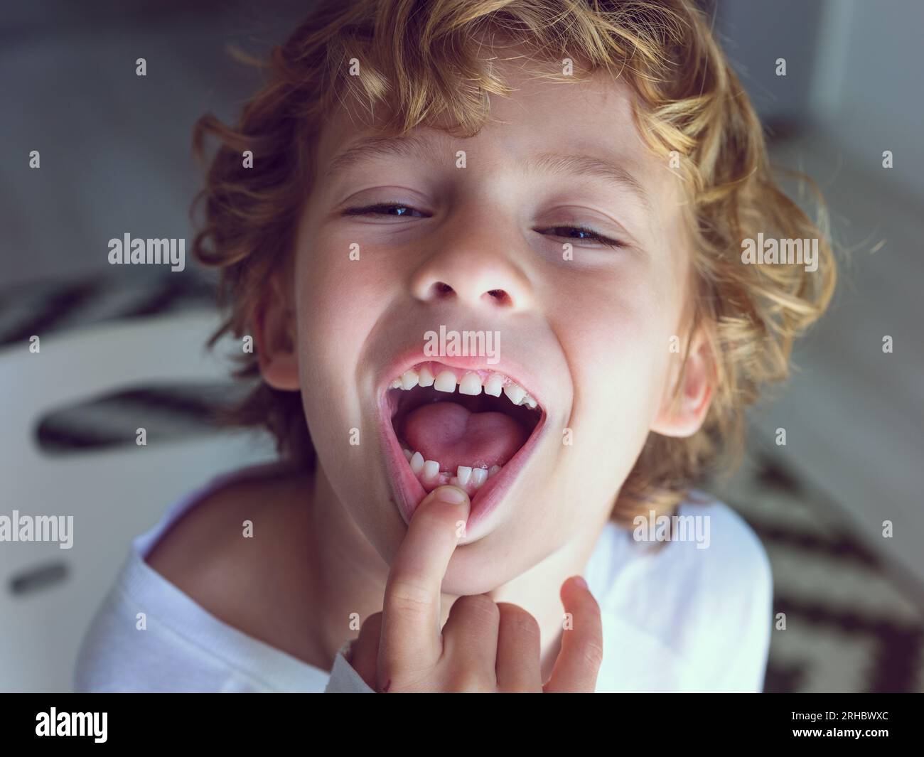 From above of cheerful child with wavy blond hair demonstrating open ...