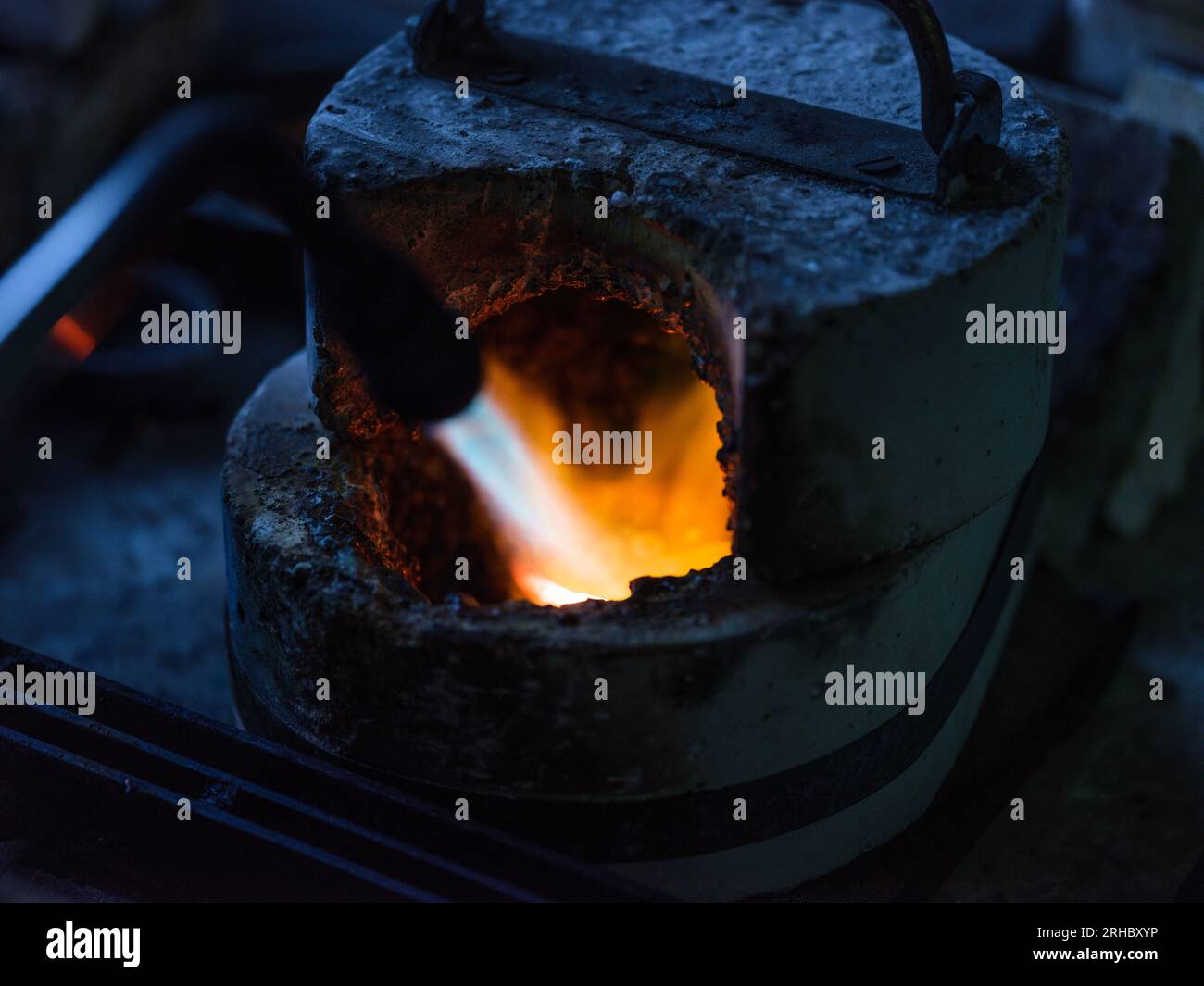 High angle of gas torch liquating metal in furnace on black background ...
