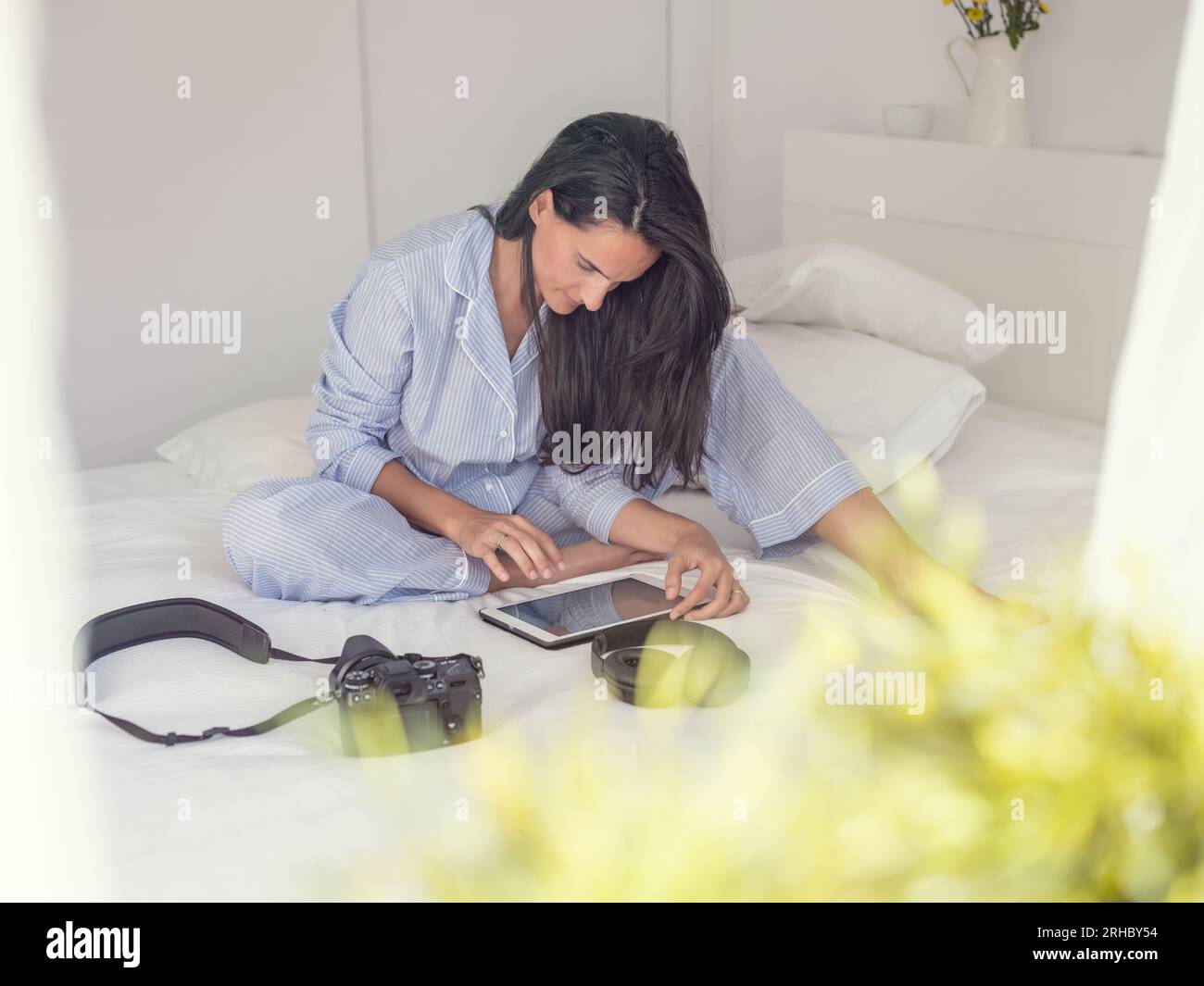 From above of concentrated female with long dark hair wearing pajamas ...