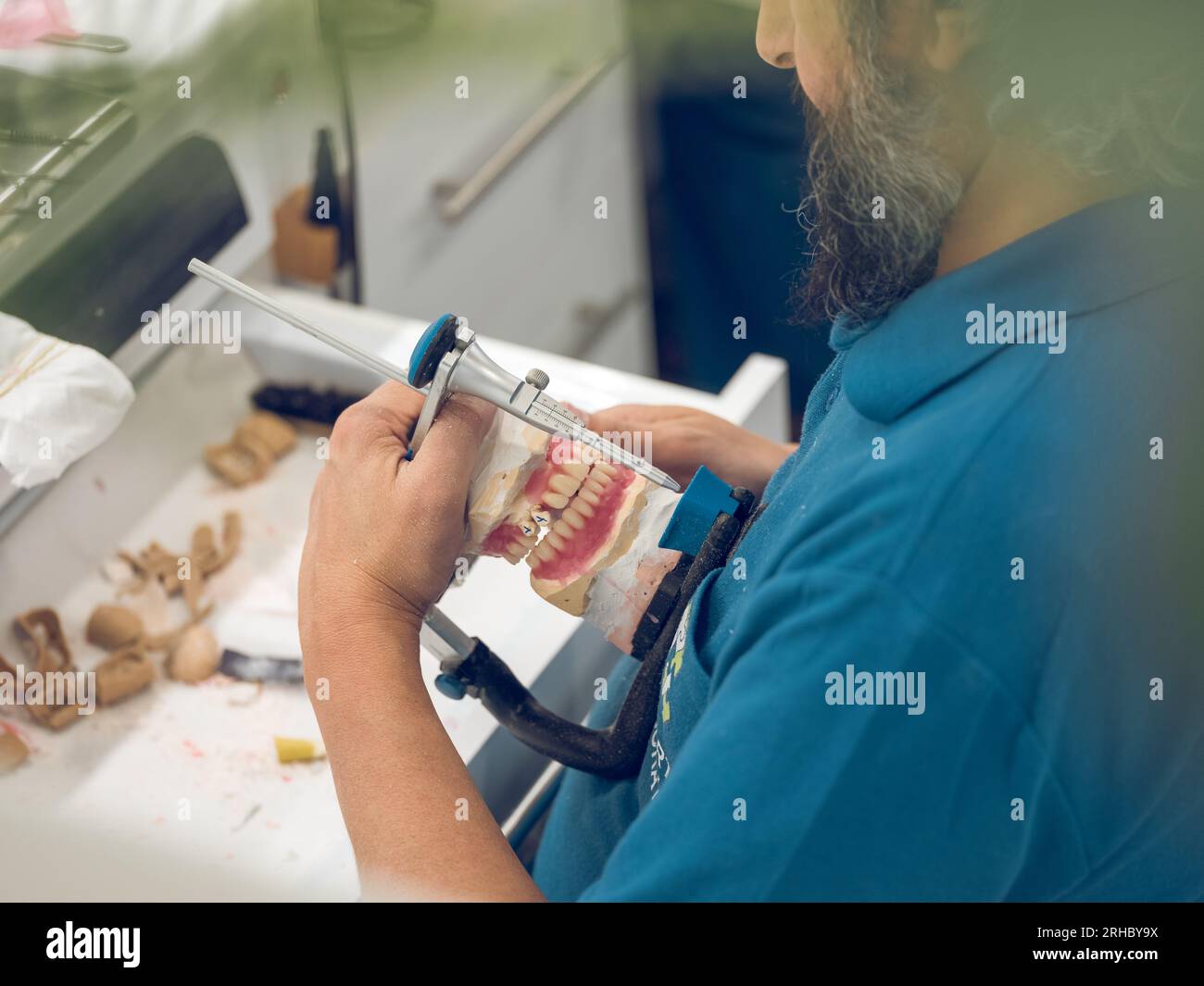 From above of side view crop senior man technician adjusting dental jaw ...