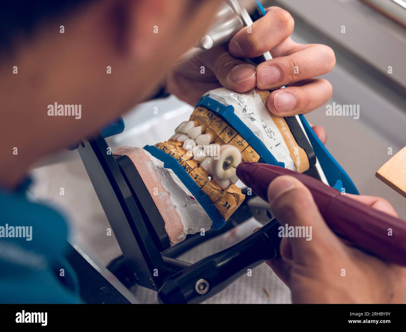 From above of crop male dental technician grinding of non removable ...