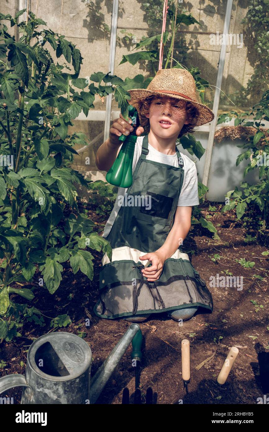 Boy spraying plants hi-res stock photography and images - Alamy