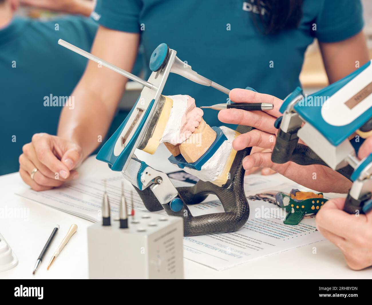 Crop female dentist consulting male dental technician working with ...