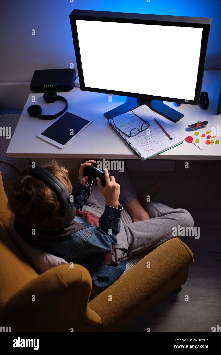 High angle of anonymous child in headset sitting with joystick in ...