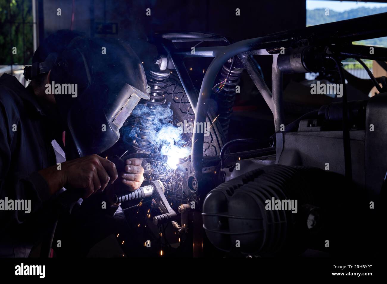 Side view of unrecognizable man in welding helmet in process of ...