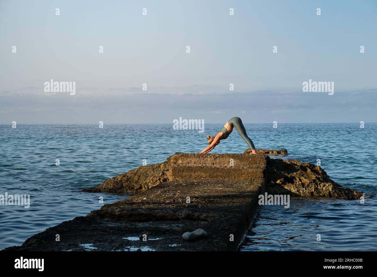 Full length side view of flexible woman bending forward during yoga ...