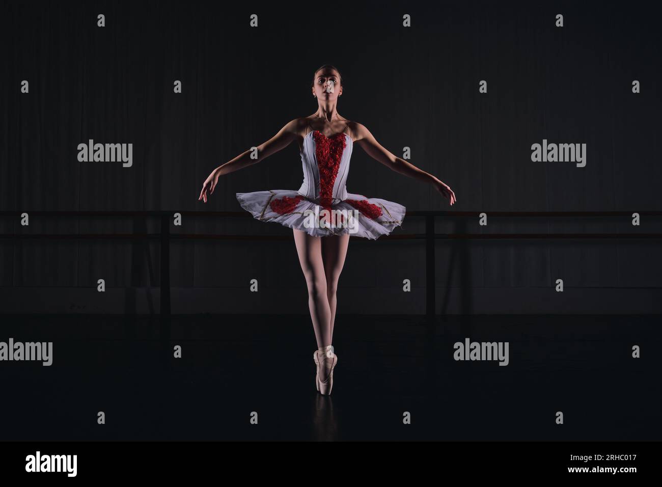 Full body of slim woman ballet dancer in tutu skirt performing tiptoes ...