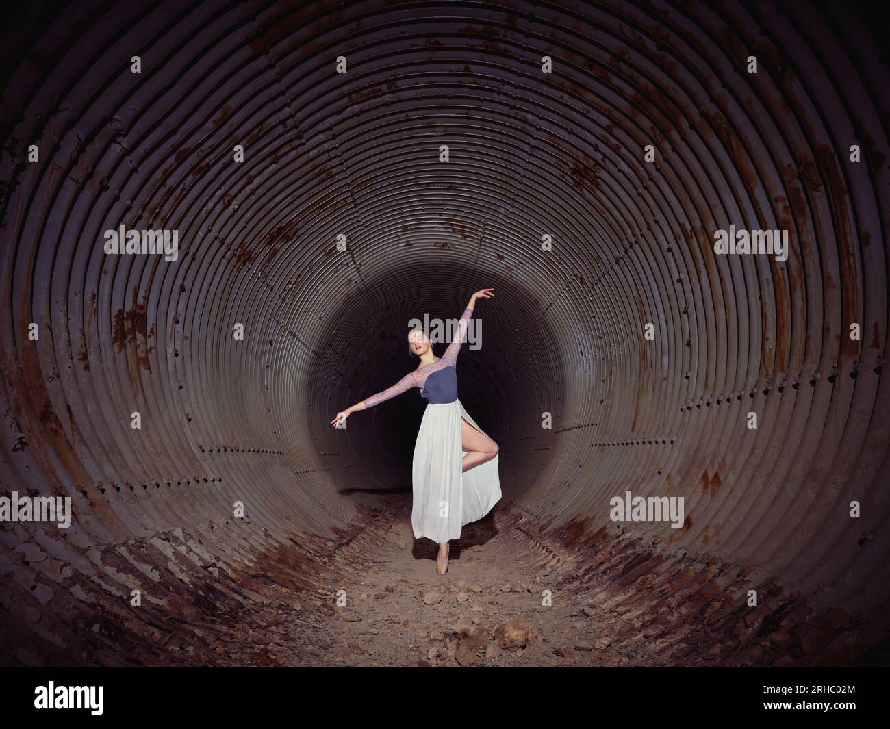 Full body of slender female ballet dancer standing on one leg while ...