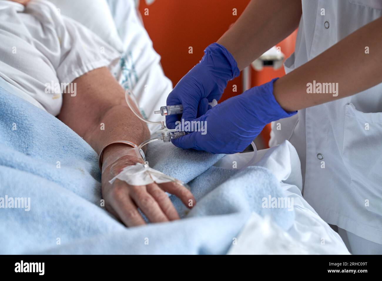 Crop anonymous nurse making injection with syringe into catheter on ...