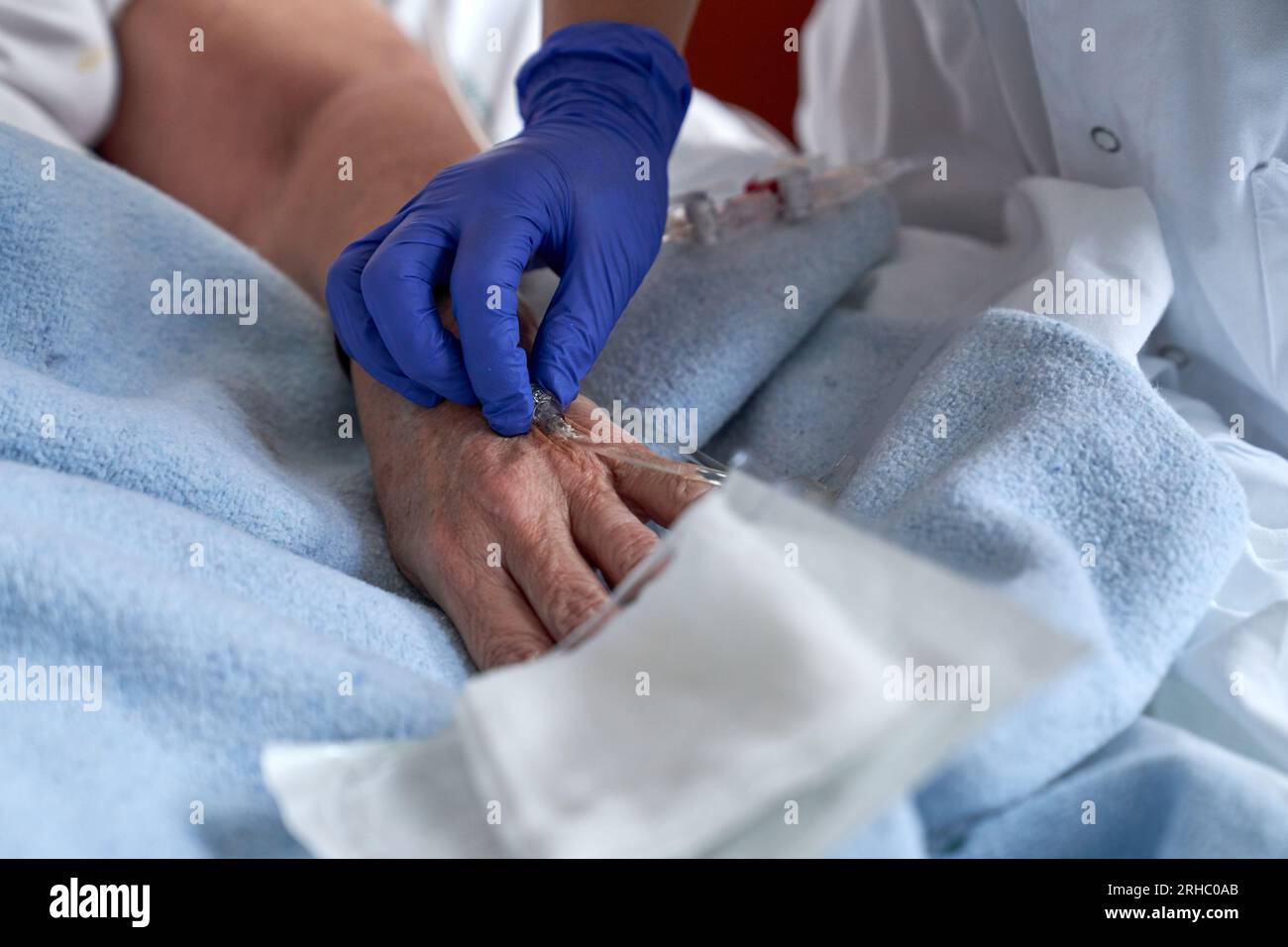 Crop anonymous doctor in latex gloves inserting catheter for ...