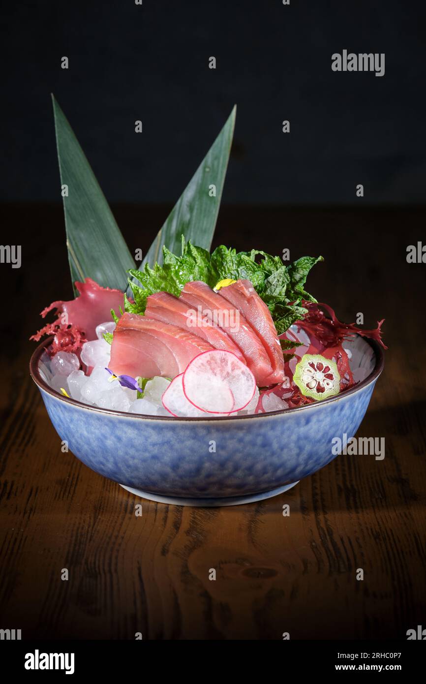 Bowl with yummy sashimi with fresh fish fillet and radish and lime ...