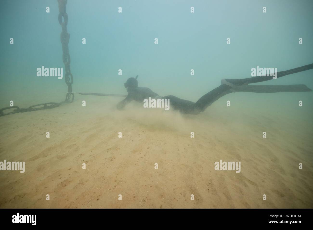 Full body side view of anonymous fisherman in wetsuit and flippers ...