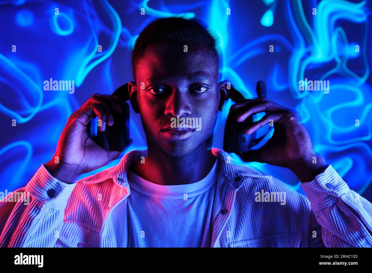 Concentrated African American male putting on headset in dark room with ...