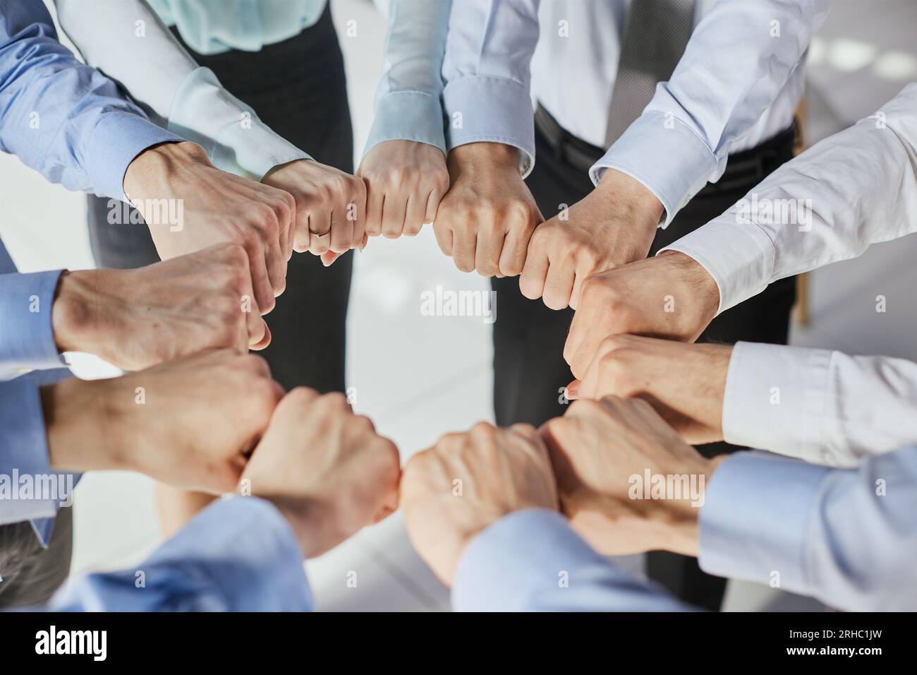 Hands, teamwork and motivation with a team of business people joining their fists in a huddle or ...