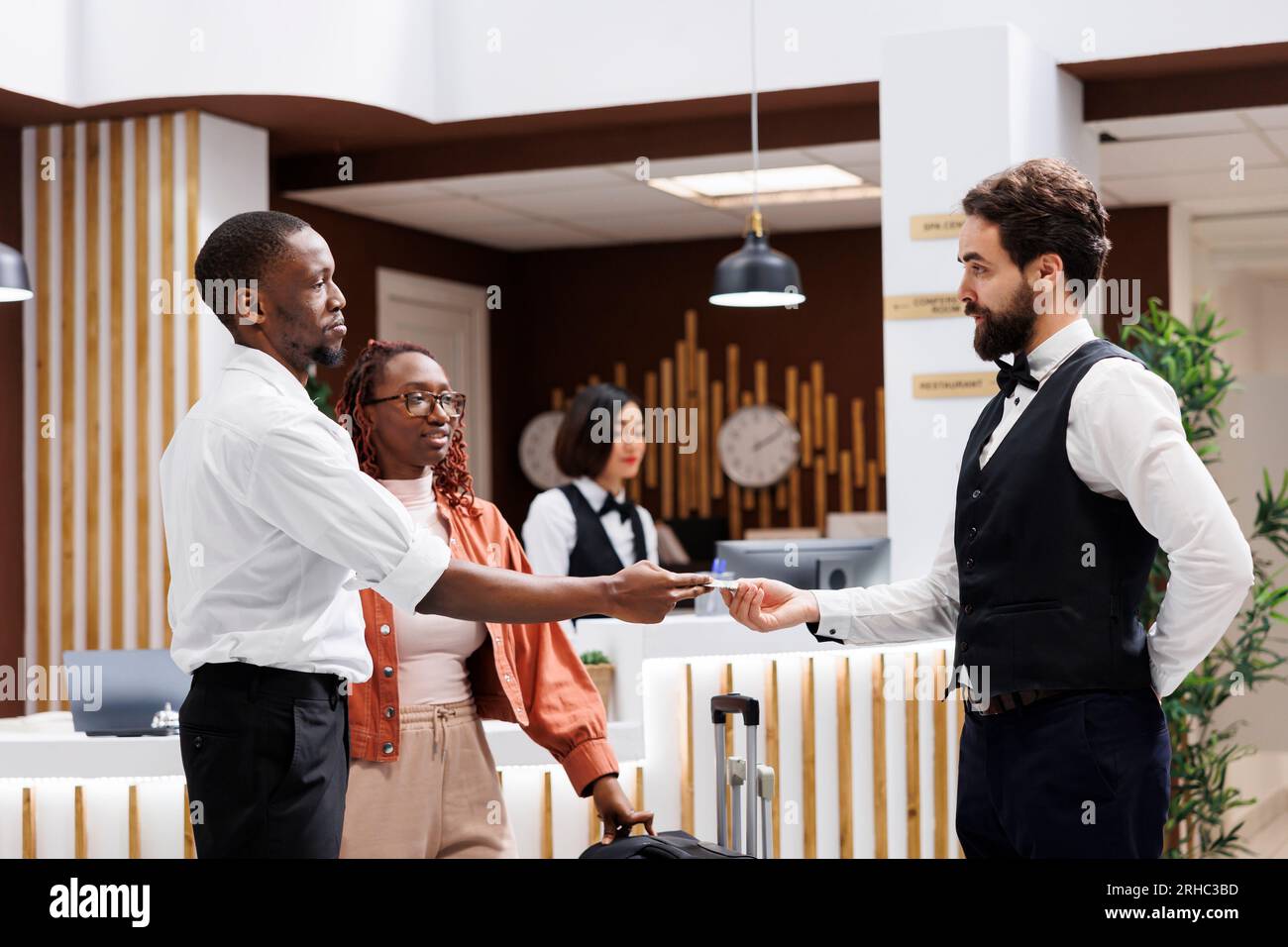 Bellboy accepting cash from hotel guest in reception lobby, offering ...