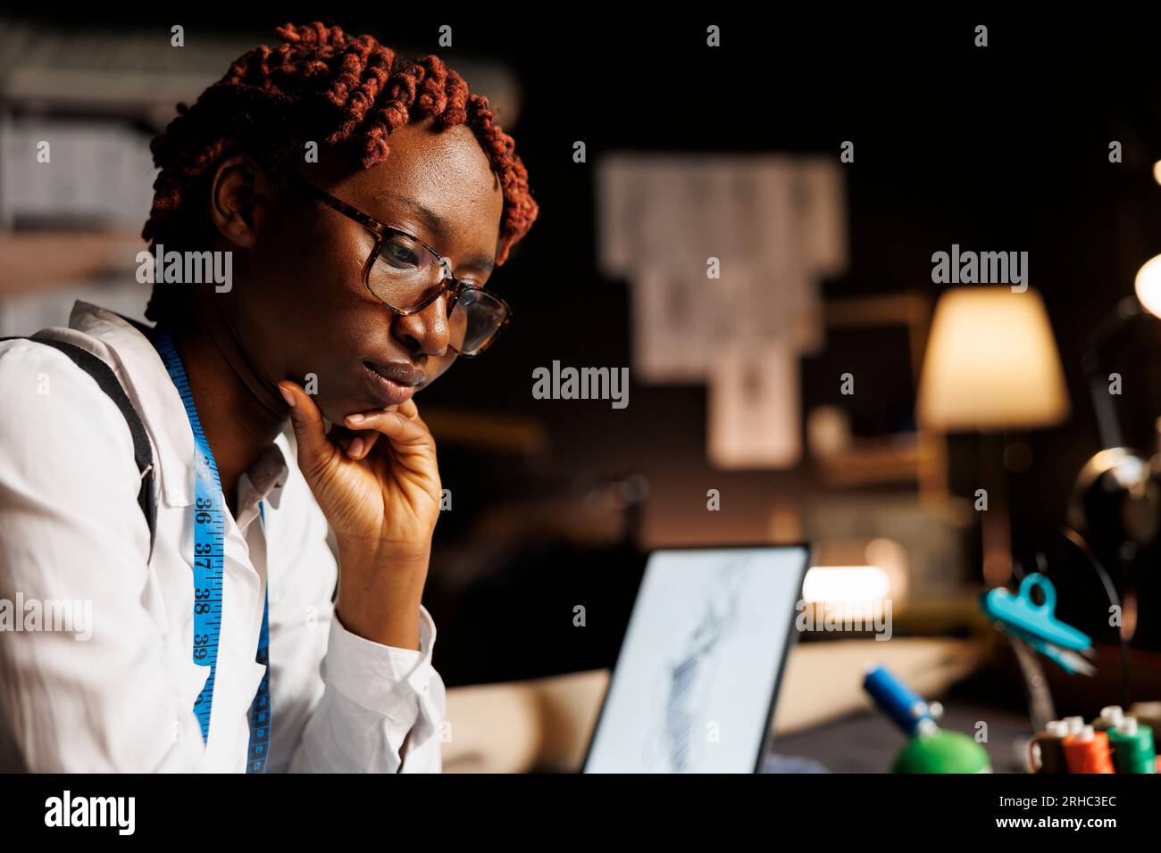 Close up of african american seamstress in tailoring studio struggling ...