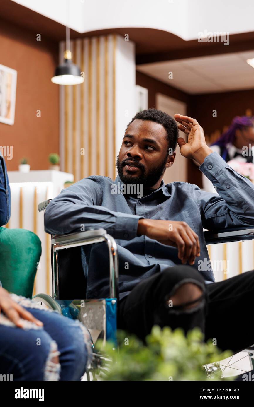 African American paralyzed man in wheelchair arriving at modern ...