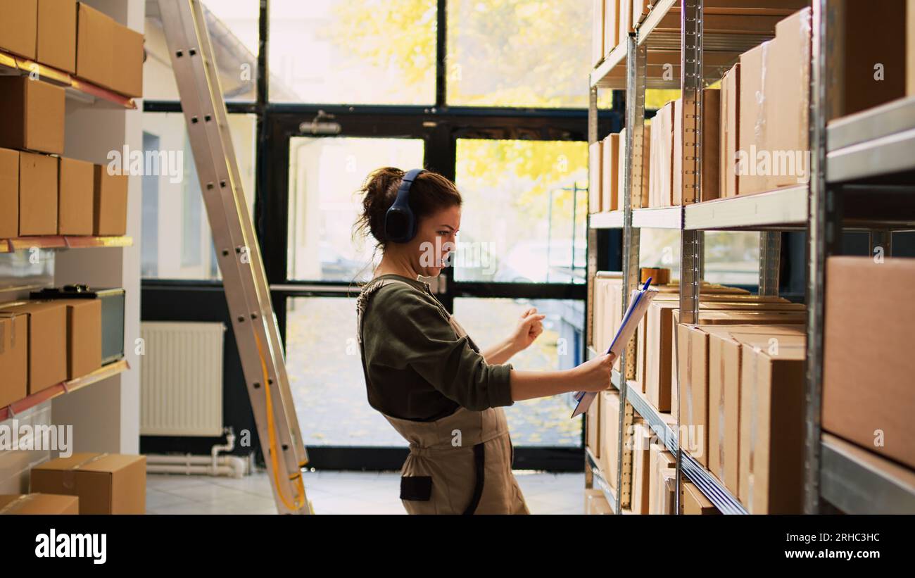 Woman dancing holding inventory list in storage room, having fun in ...