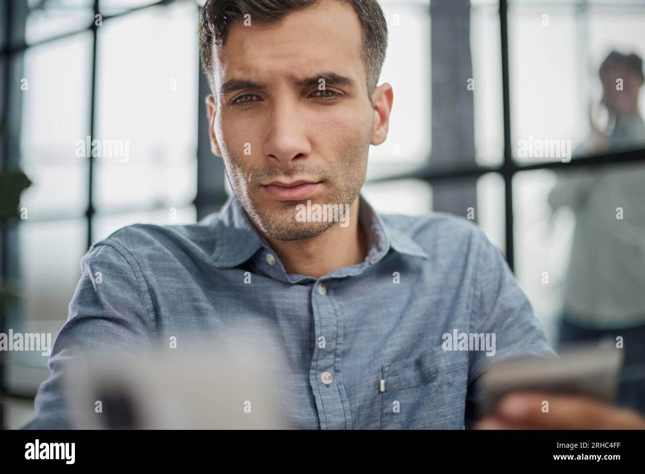 Formally dressed man sits on a sofa and enters a credit card number ...