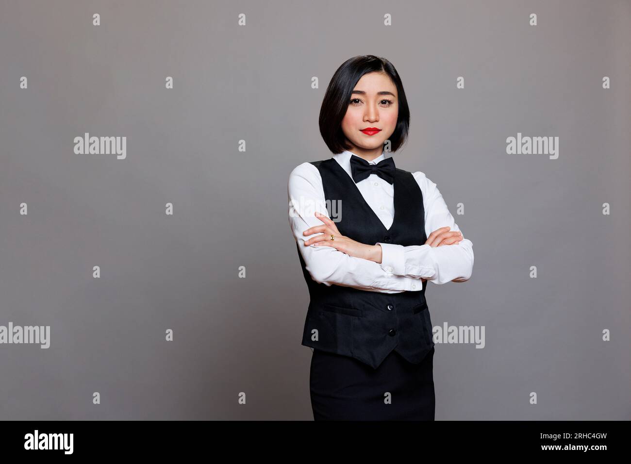 Confident asian restaurant receptionist posing with folded arms and ...