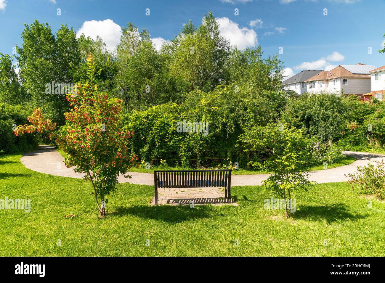 Circular asphalt path, in a residential area, passes next to a metal ...